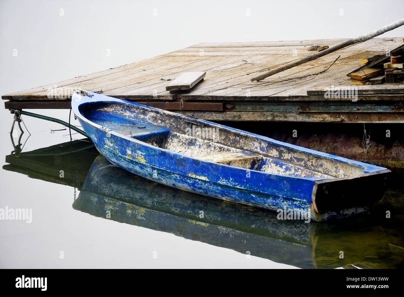Old small blue boat abandoned in a dock Stock Photo - Alamy