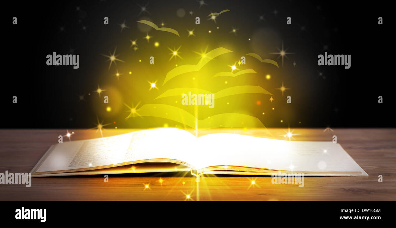 Open book with golden glow flying paper pages Stock Photo - Alamy