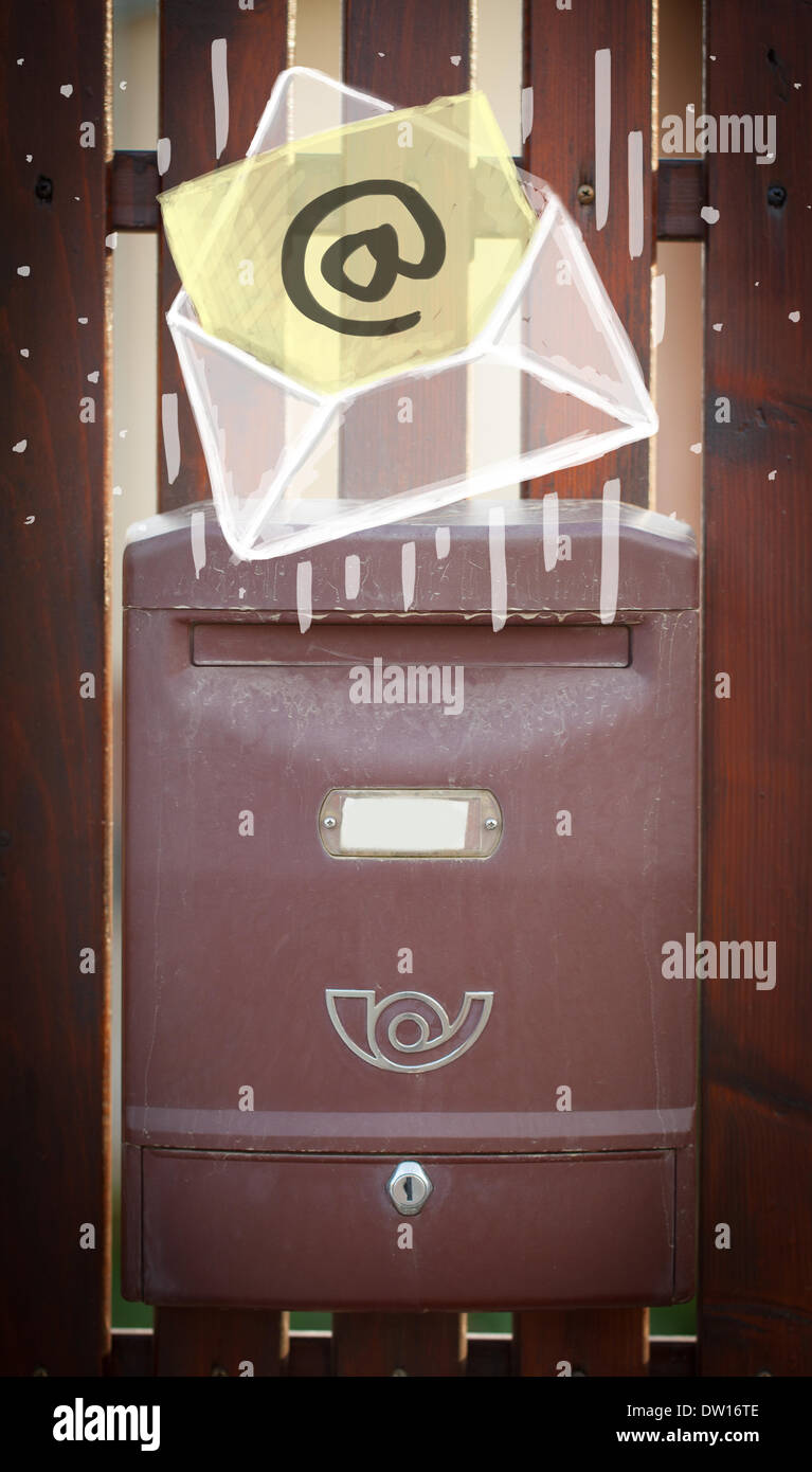 Envelope with email sign dropping into mailbox Stock Photo - Alamy