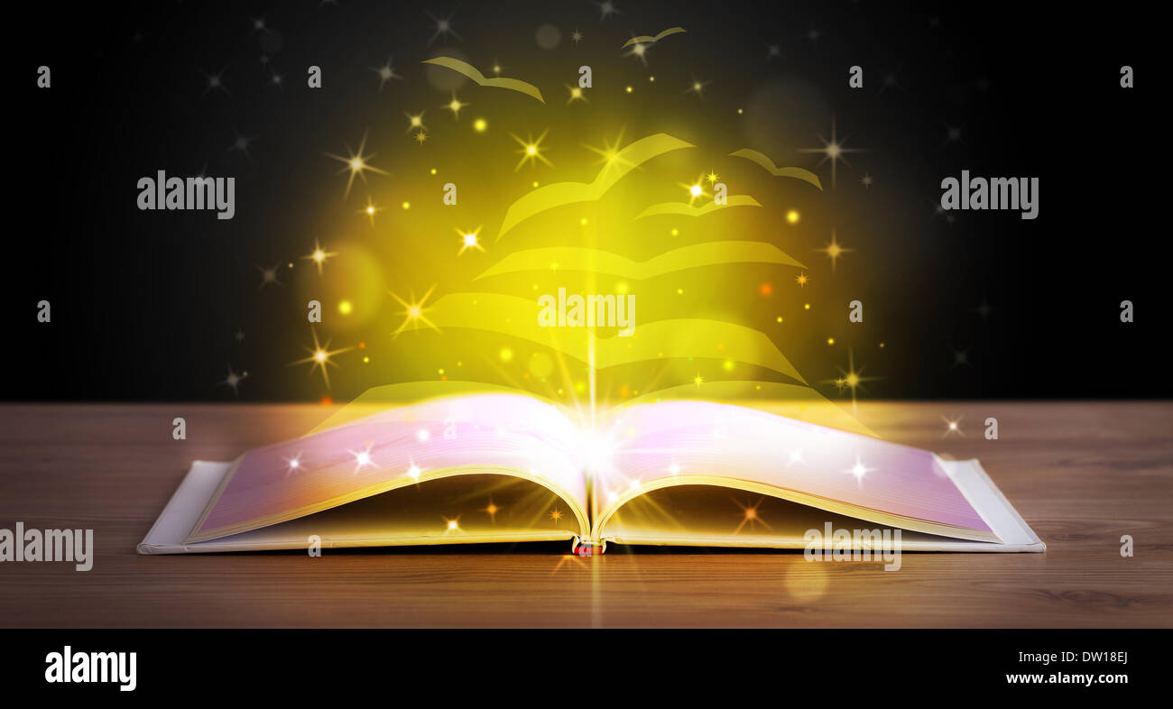 Open book with golden glow flying paper pages Stock Photo - Alamy
