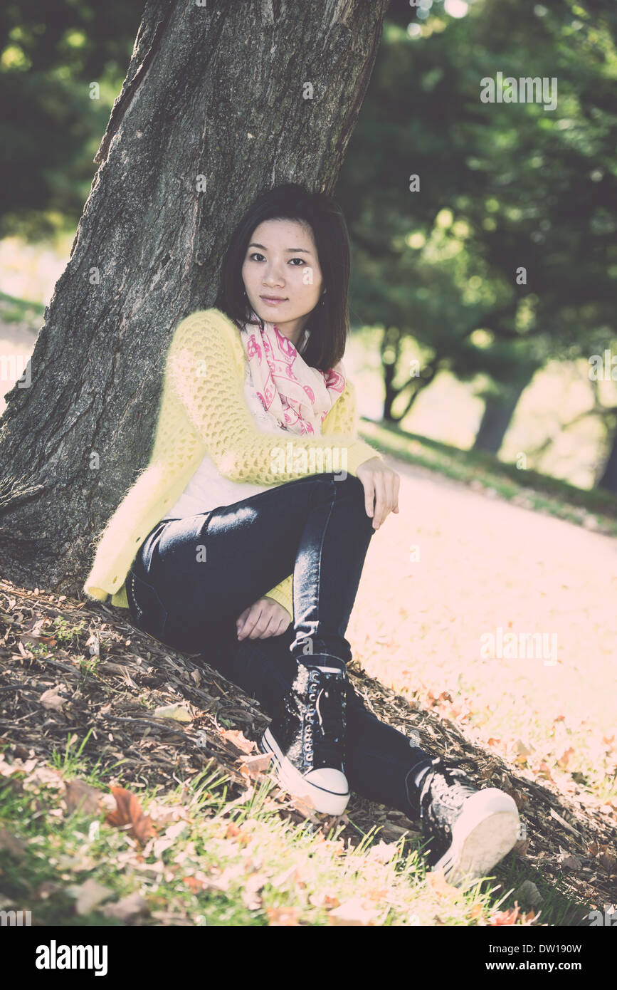 Girl sitting against tree hi-res stock photography and images - Alamy