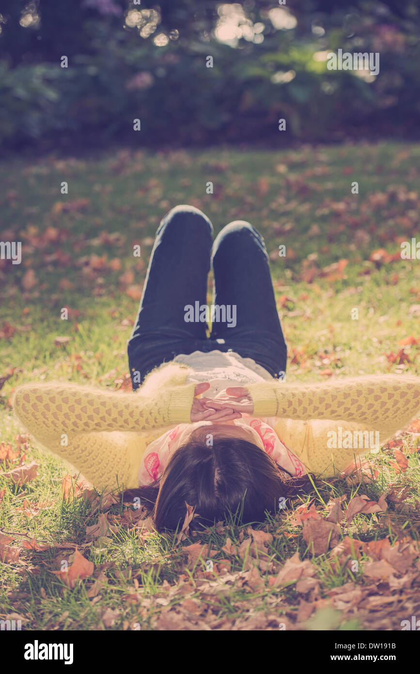 Woman laying in grass Stock Photo - Alamy