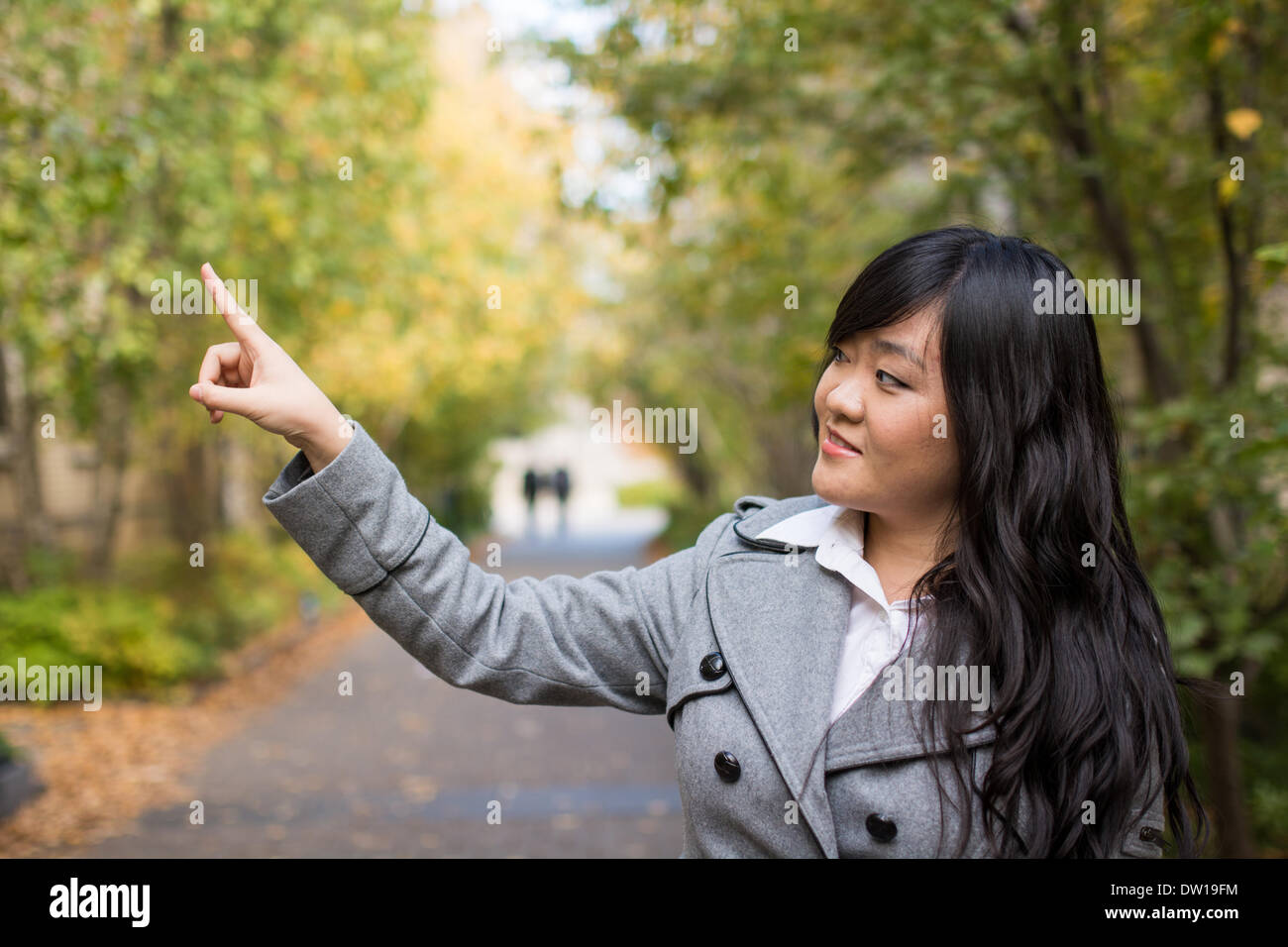 Portrait of woman pointing at something Stock Photo - Alamy
