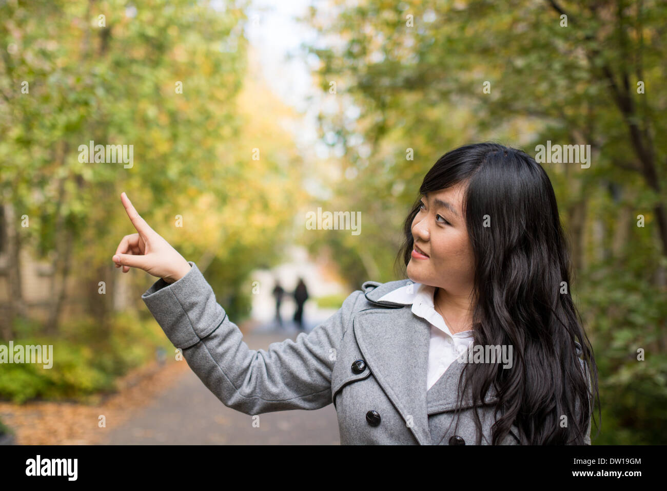 Portrait of woman pointing at something Stock Photo - Alamy