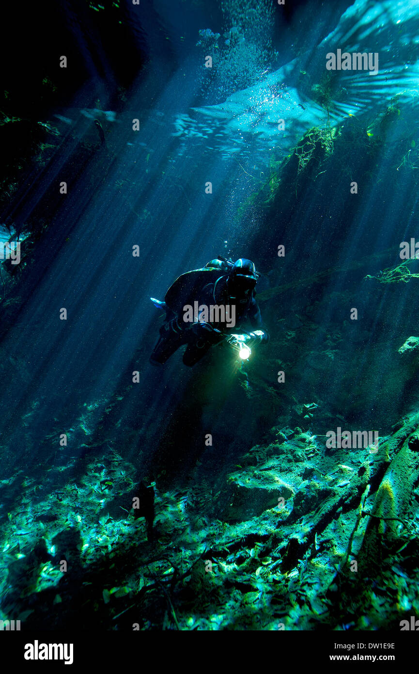Scuba diver swimming thru the underwater Chac Mool Cenote cave, Yucatan ...