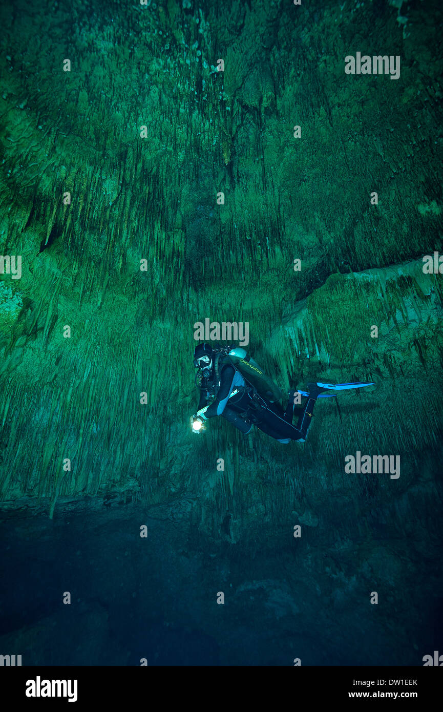 Scuba diver swimming thru the underwater Chac Mool Cenote cave, Yucatan ...