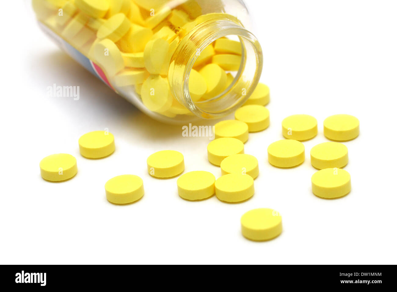yellow pills around transparent bottle Stock Photo - Alamy