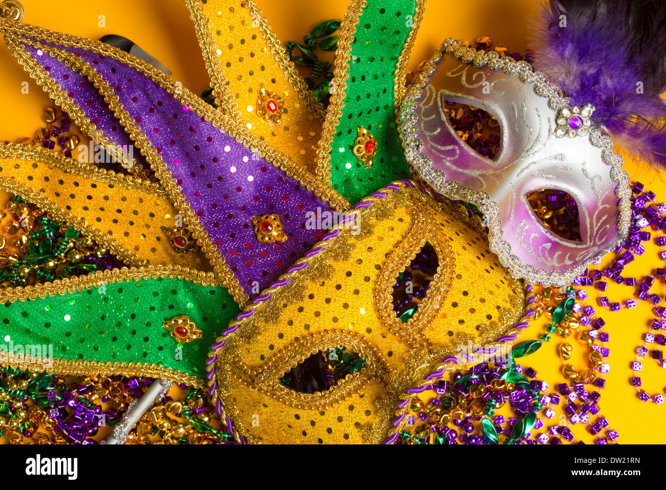A festive, colorful group of mardi gras or carnivale mask on a yellow ...