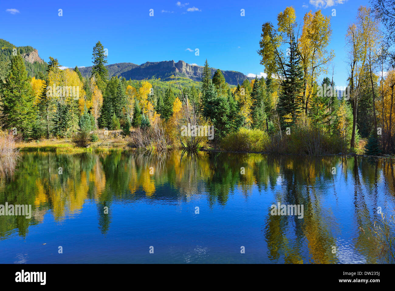 colourful mountains of Colorado reflecting in a lake during foliage ...