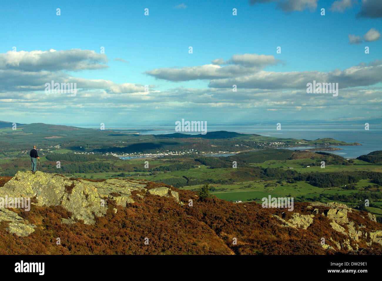 A walker looks across Kippford and the Colvend Coast from the summit of ...