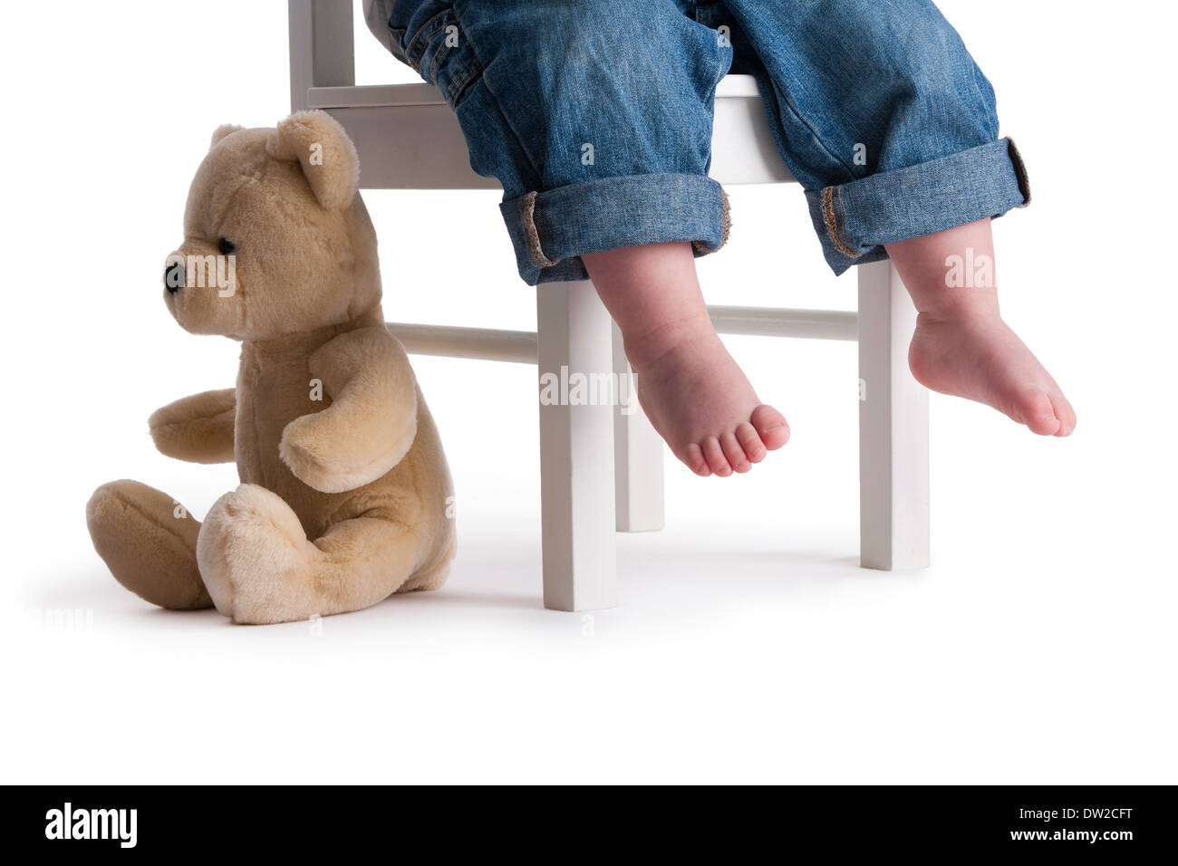 Childs feet on a small chair on white background Stock Photo - Alamy