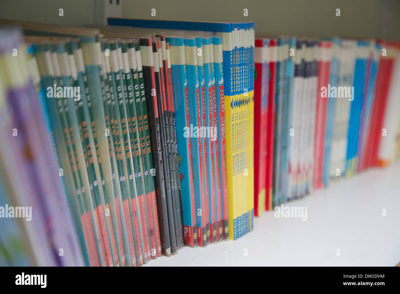 A line of school various text books on a shelf Stock Photo - Alamy