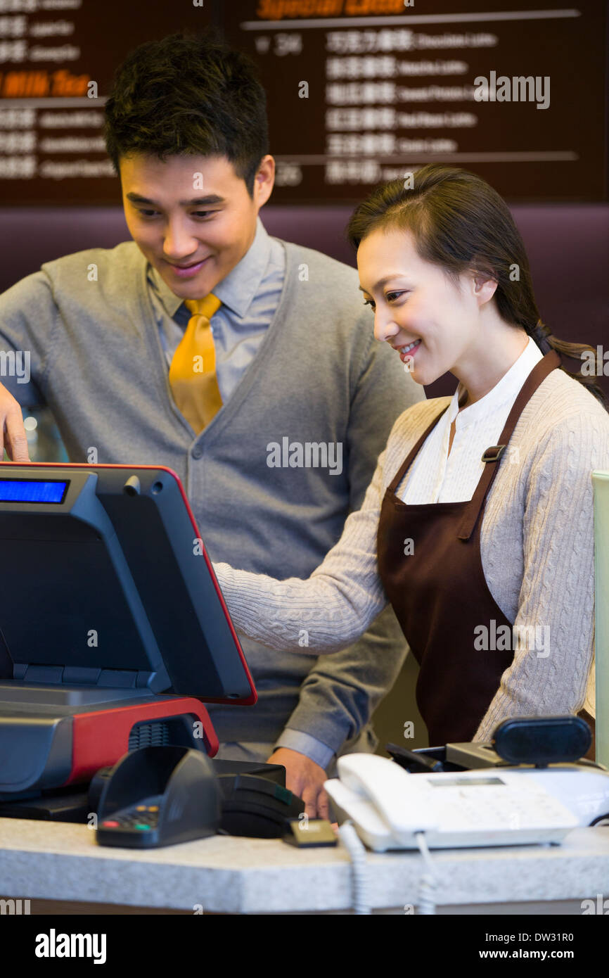 Coffee store shopkeeper and waitress using cash register Stock Photo ...