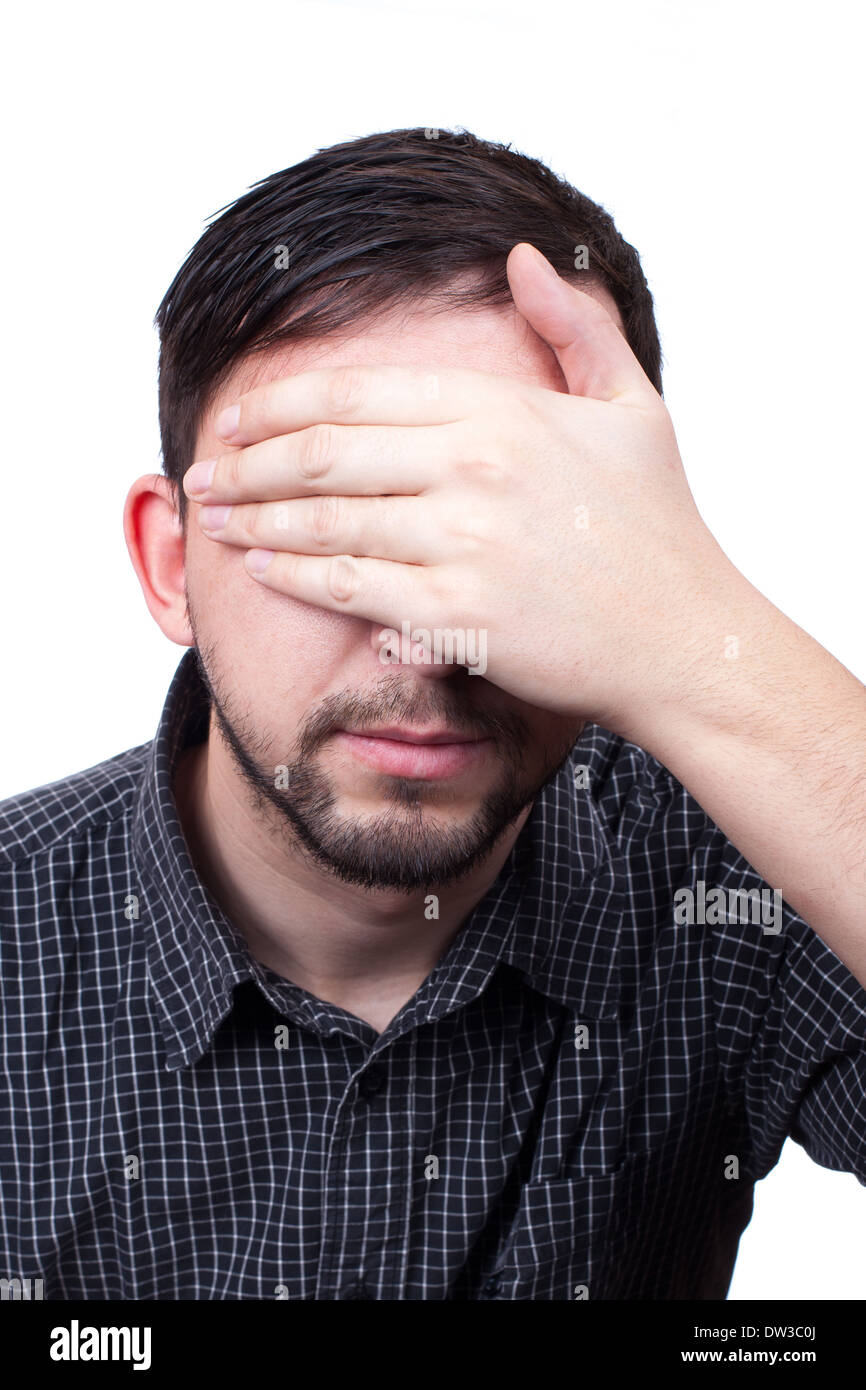 Young man with hand over his eyes isolated on white background Stock ...