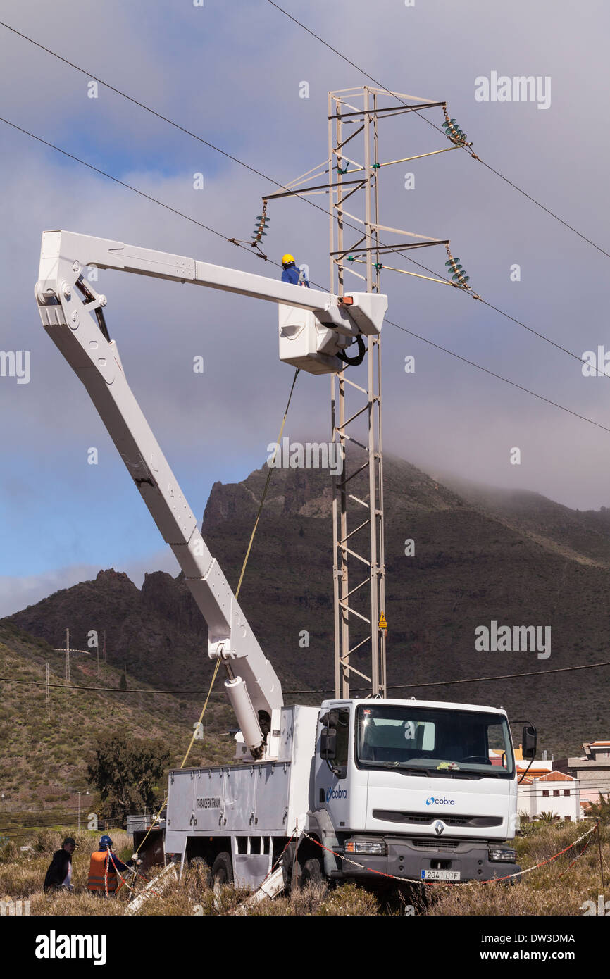 Power workers in a cherry picker working on high tension cables Stock ...