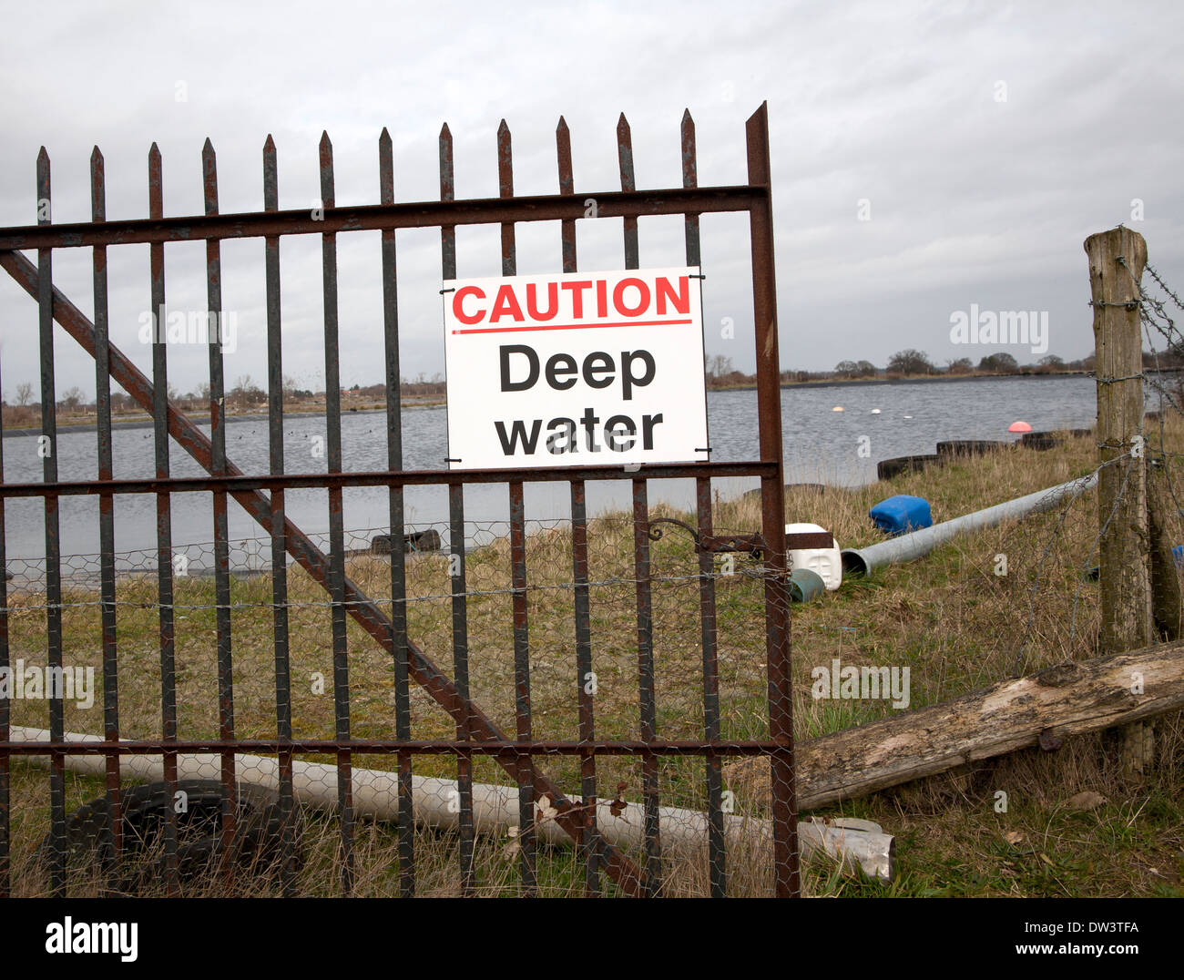Sign warning of deep water on gate into farm irrigation water storage ...