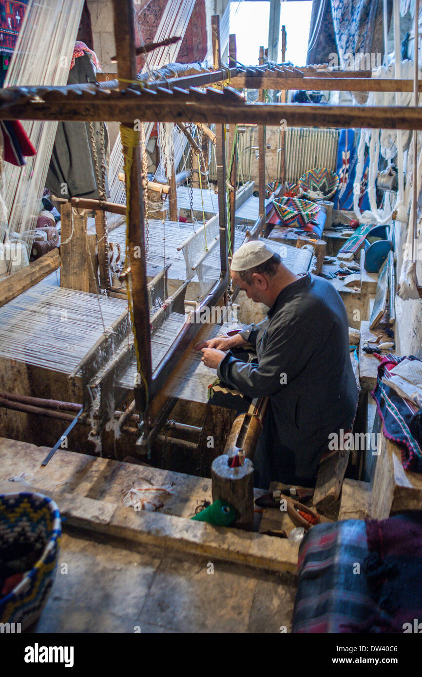 Rug weaver working in a pit loom in the central market of Aleppo, Syria ...