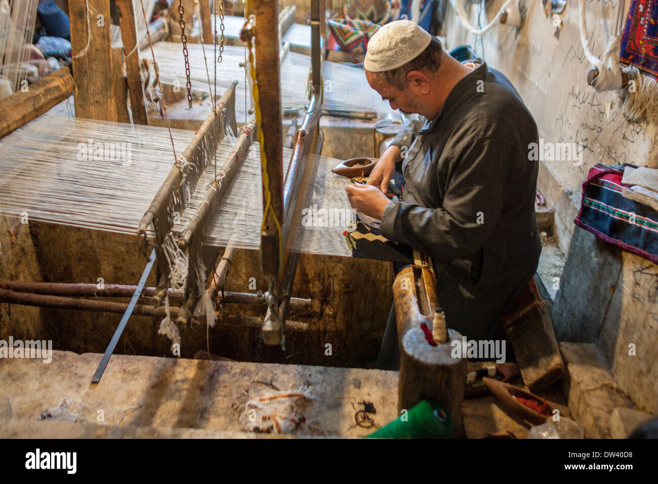 Rug weaver working in a pit loom in the central market of Aleppo, Syria ...
