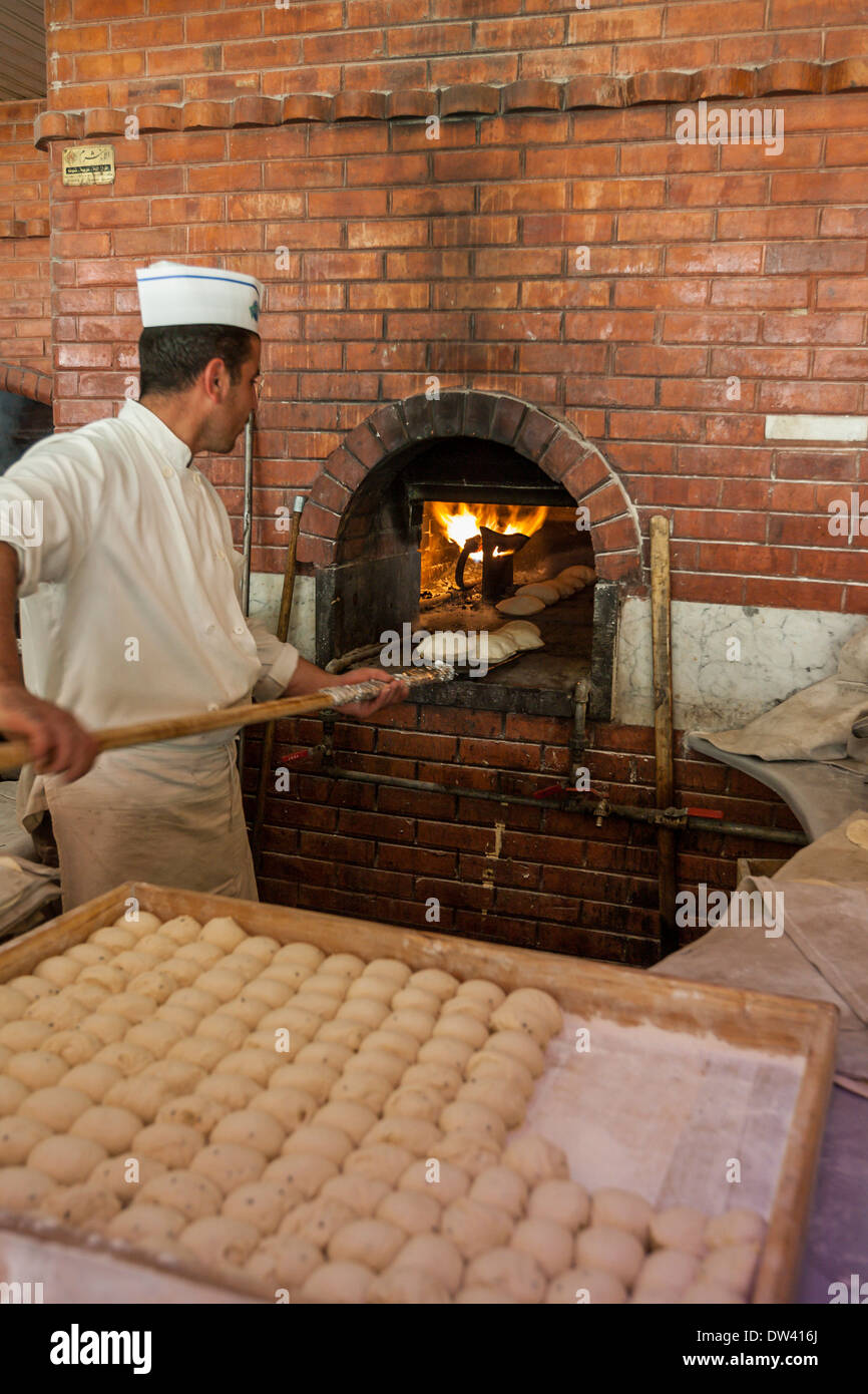 Chef puts pita bread to cook in wood burning oven in restaurant in ...