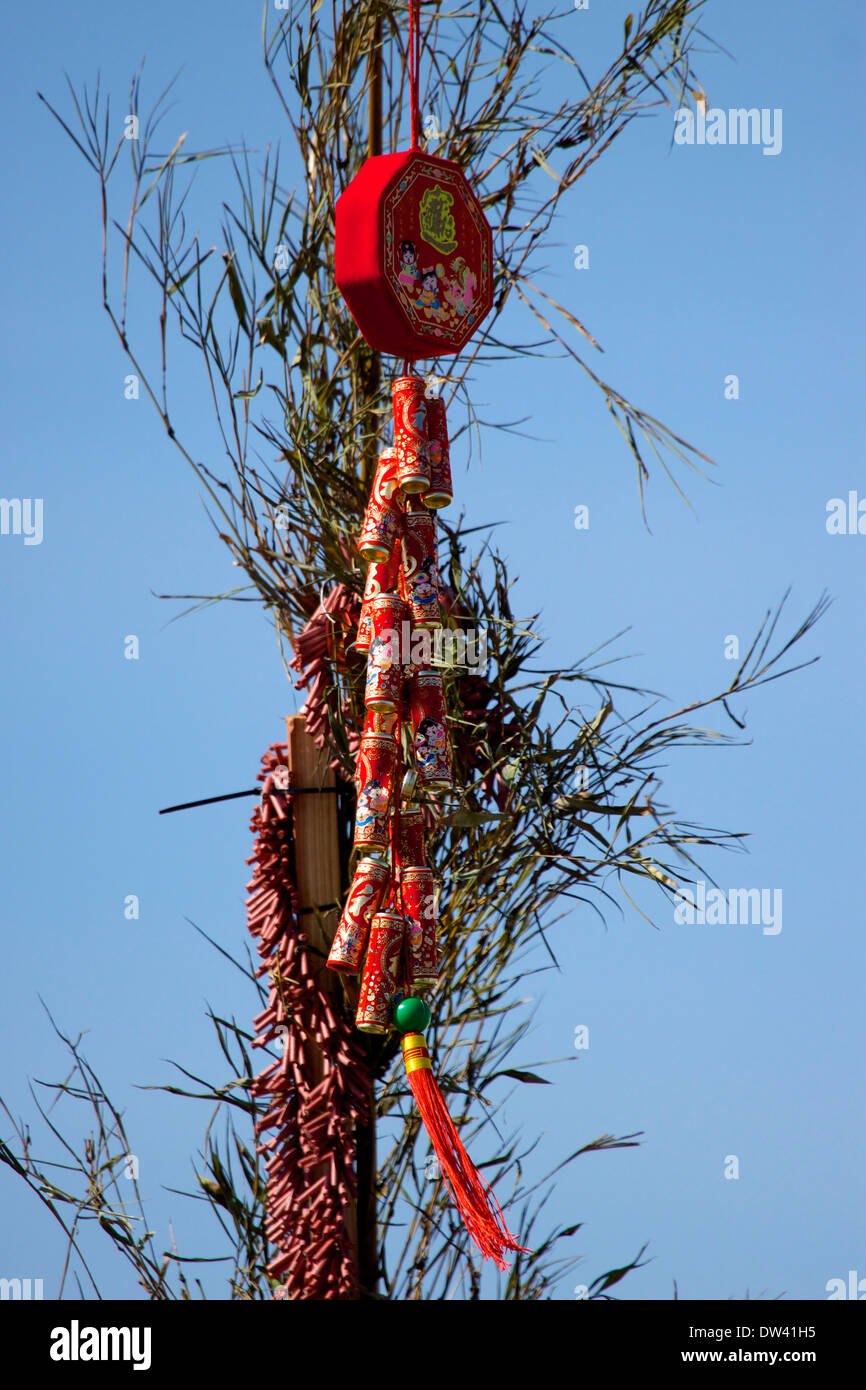 Fire crackers and good luck decorations hanging from bamboo during the ...