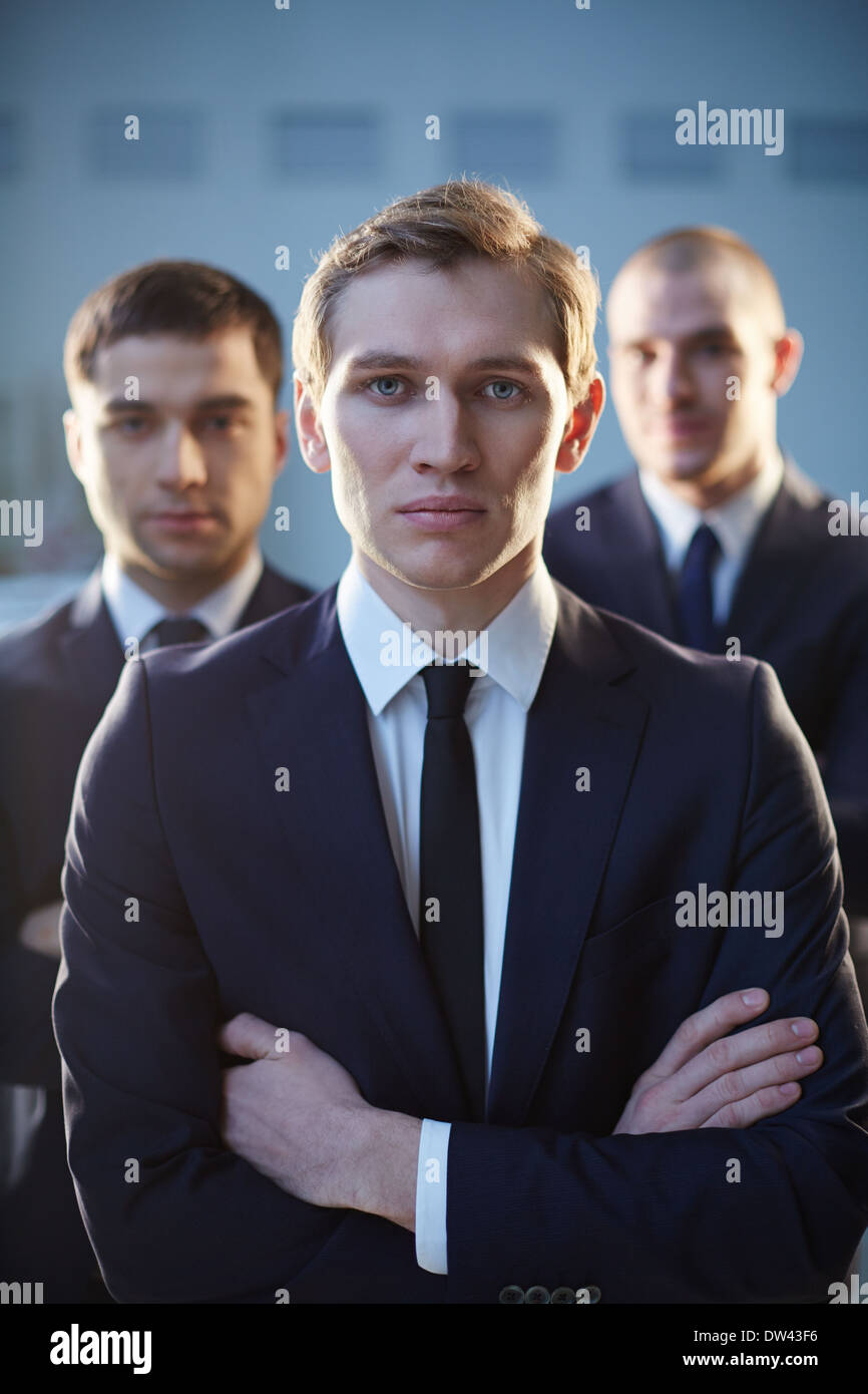 Vertical portrait of a serious leader of the company standing on the ...