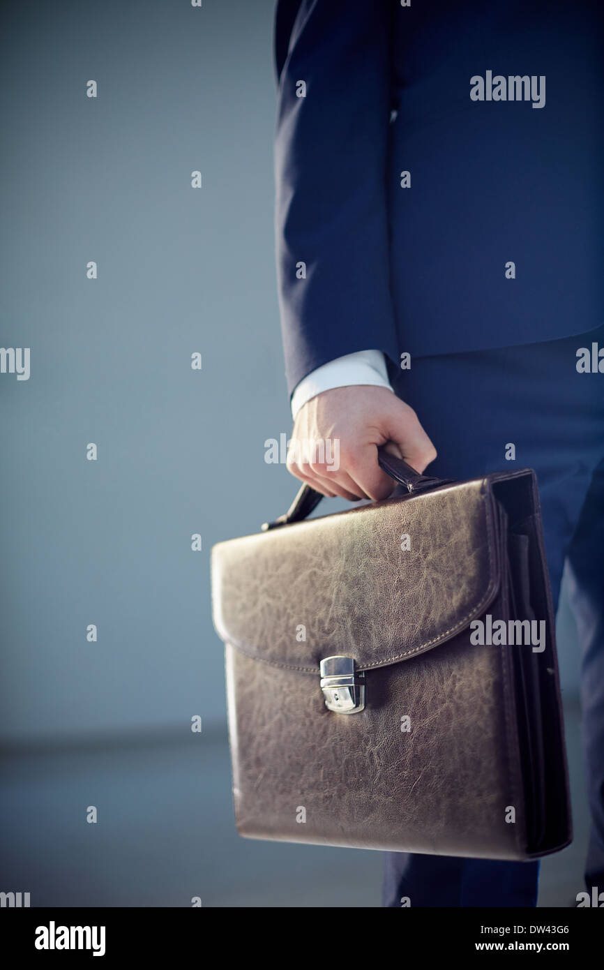 Vertical cropped image of a businessperson carrying a leather briefcase ...