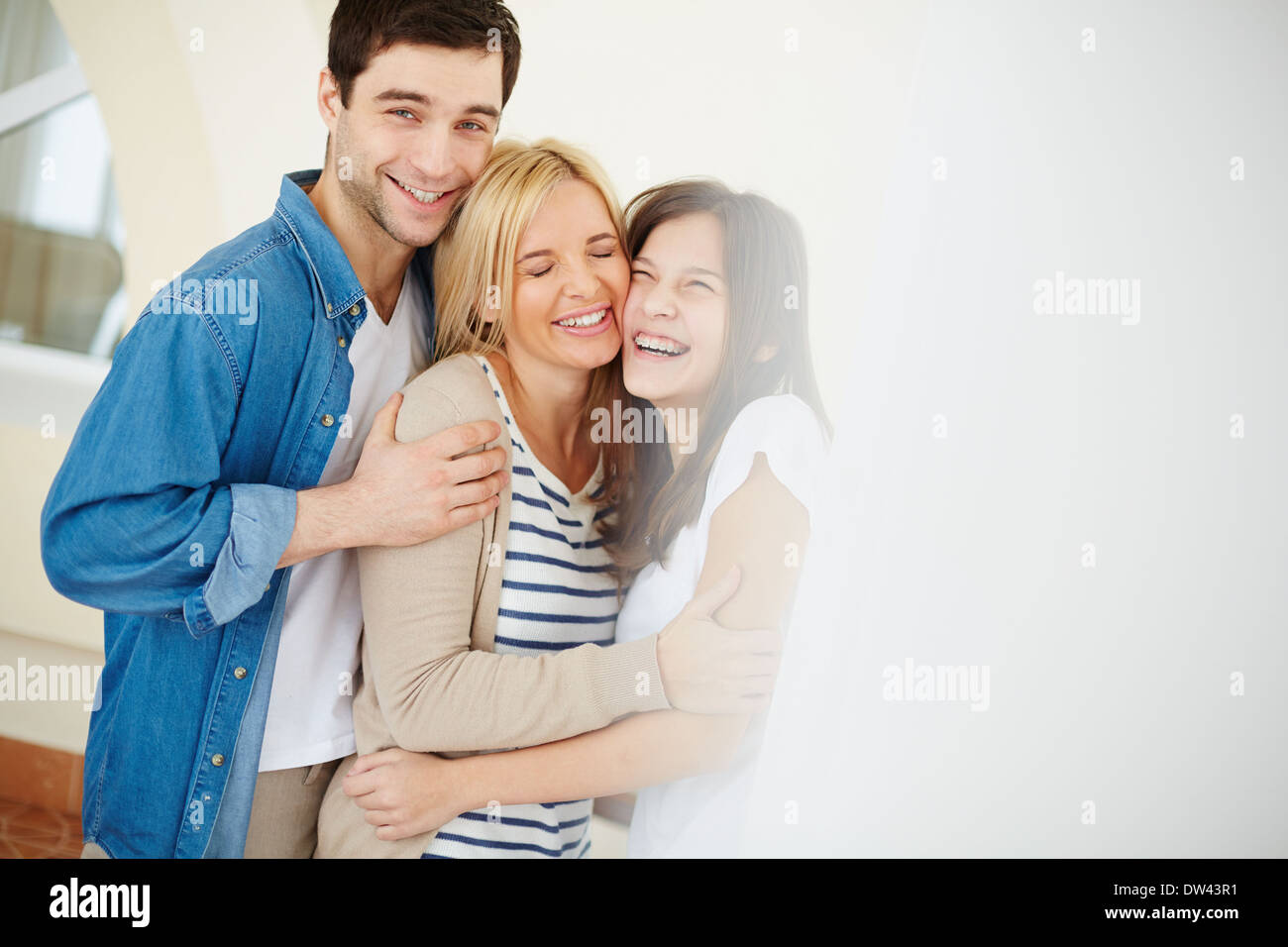 Portrait of joyful family of three at home Stock Photo - Alamy