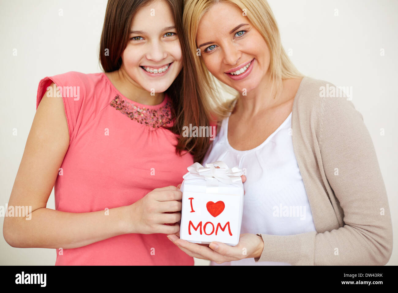 Teenage girl and her mom looking at camera and smiling Stock Photo - Alamy