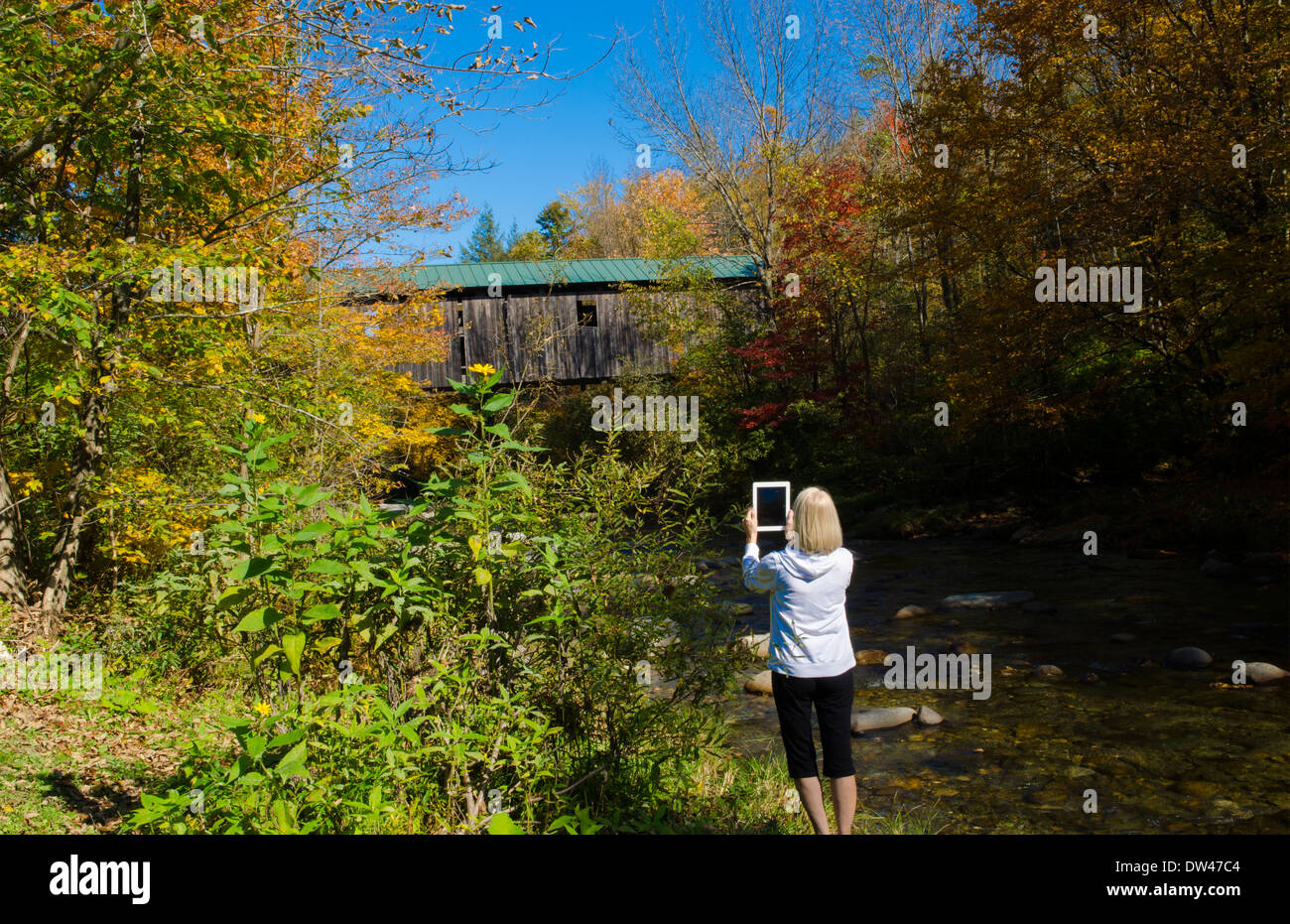 Jeffersonville Vermont covered bridge woman taking pictures with I-pad ...