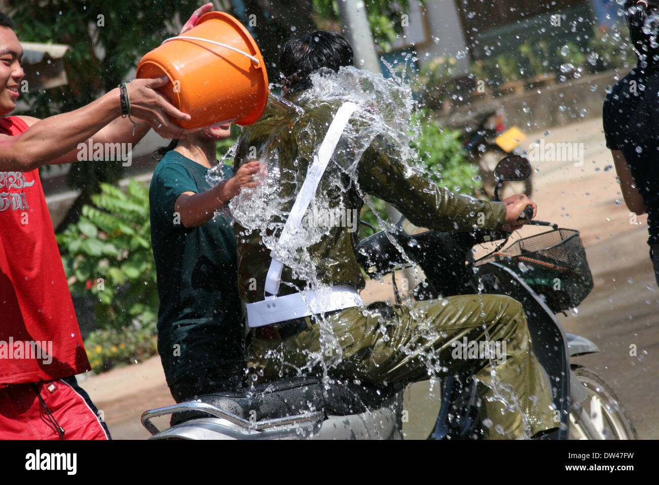 A man is throwing a bucket of water on a policeman on a city street ...