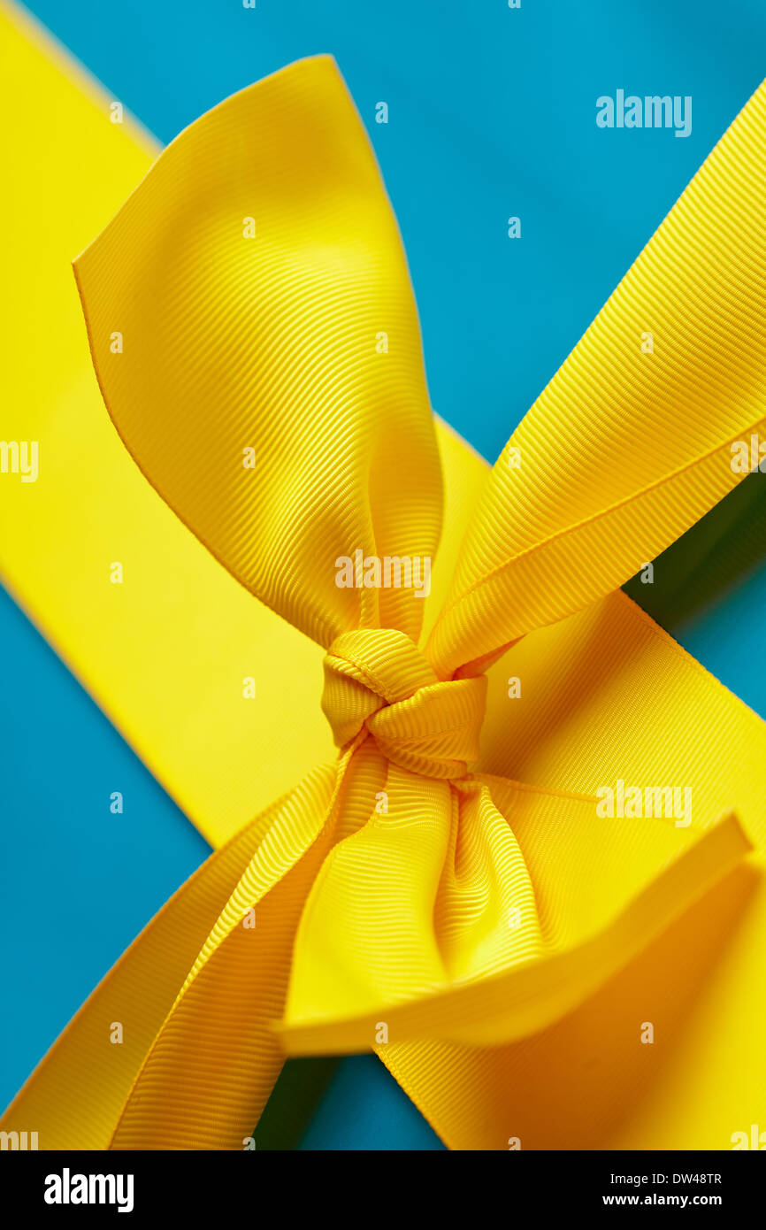Yellow Ribbon around a blue christmas gift Stock Photo - Alamy