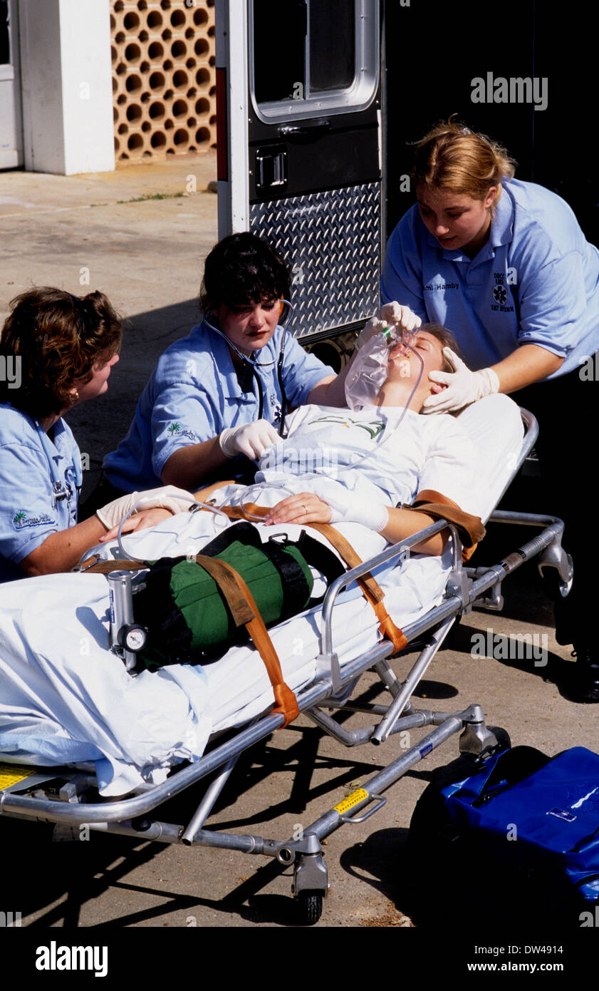 Emergency medical care on serious injury with ambulance and ER helpers ...