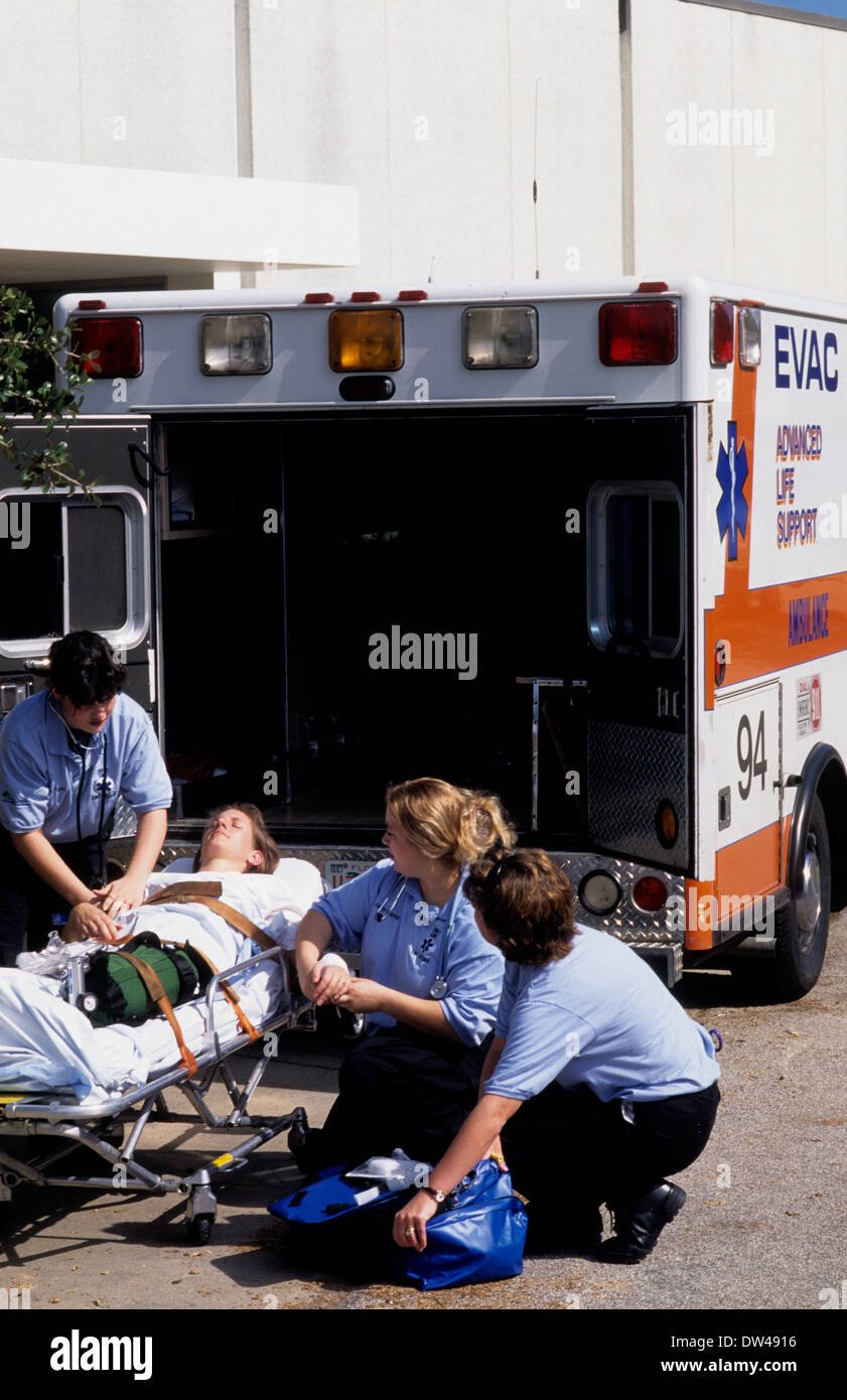 Emergency medical care on serious injury with ambulance and ER helpers ...
