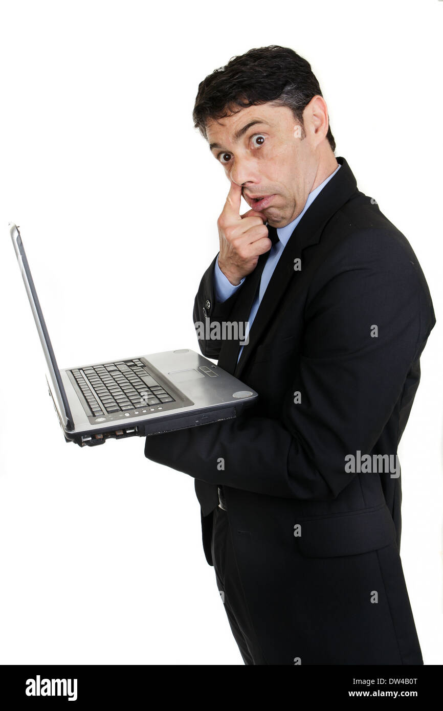 Middle-aged businessman standing sideways handholding his laptop ...