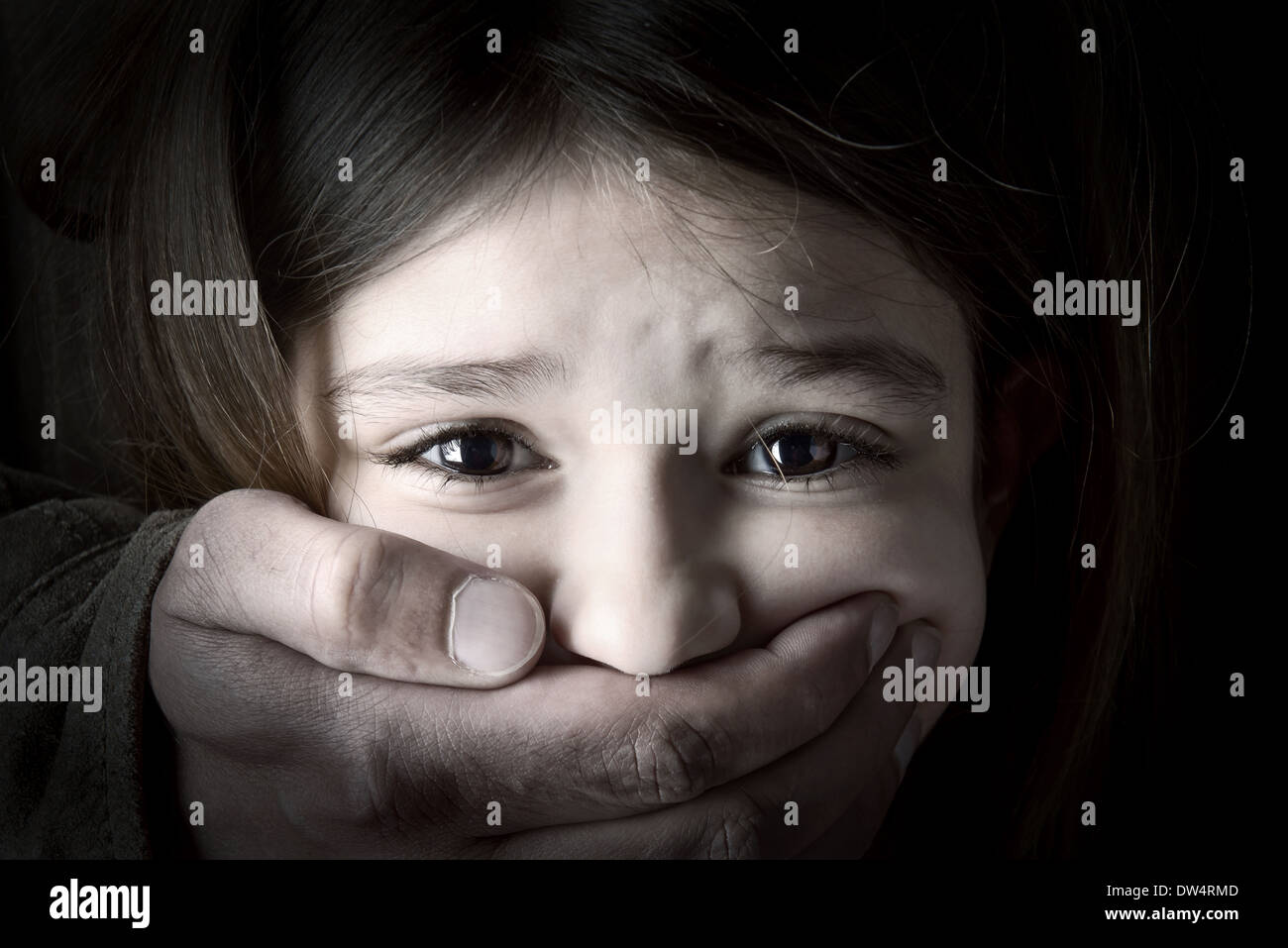 Scared young girl with an adult man's hand covering her mouth Stock ...