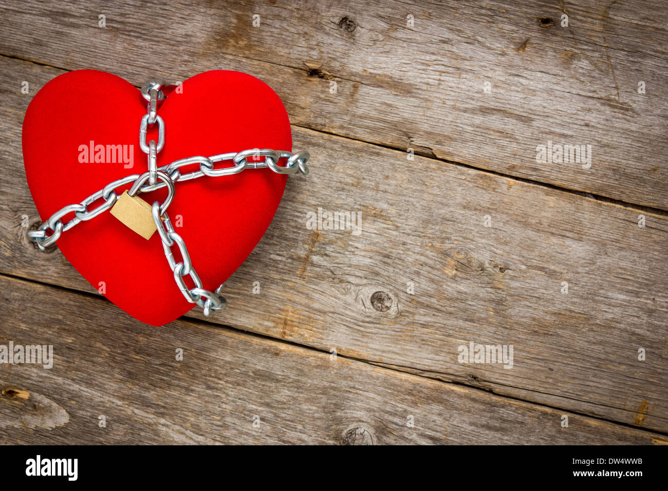 Love lockdown : heart shape with chains on wooden background Stock ...