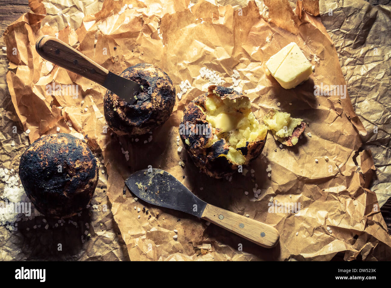 Jacket potatoes with butter made in campfire Stock Photo - Alamy
