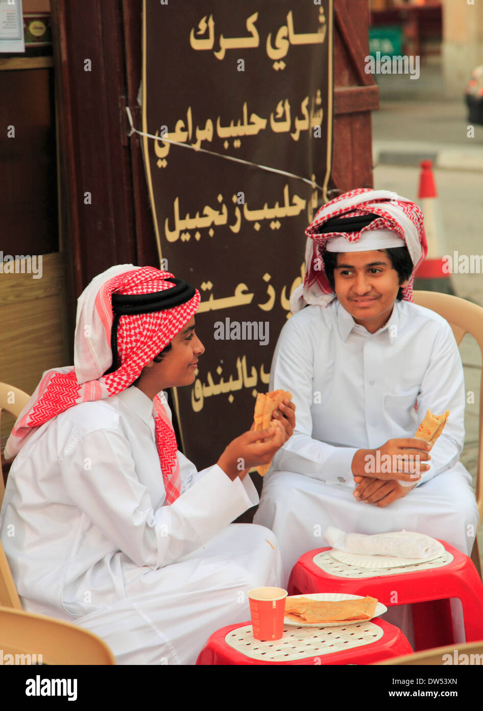 Qatar, Doha, Souq Waqif, boys eating, street scene Stock Photo - Alamy