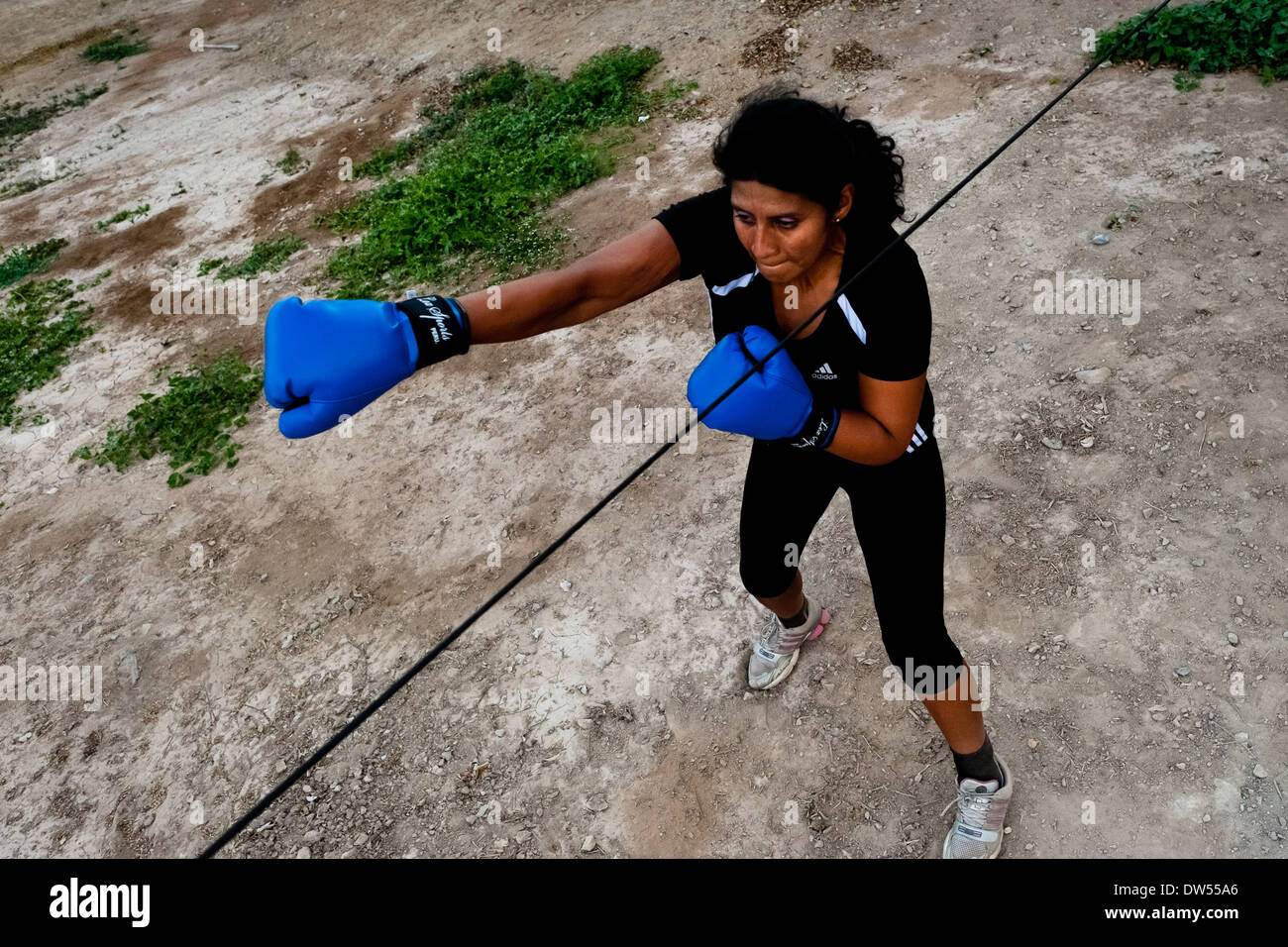 A Peruvian woman practices punching and movement while training in the ...