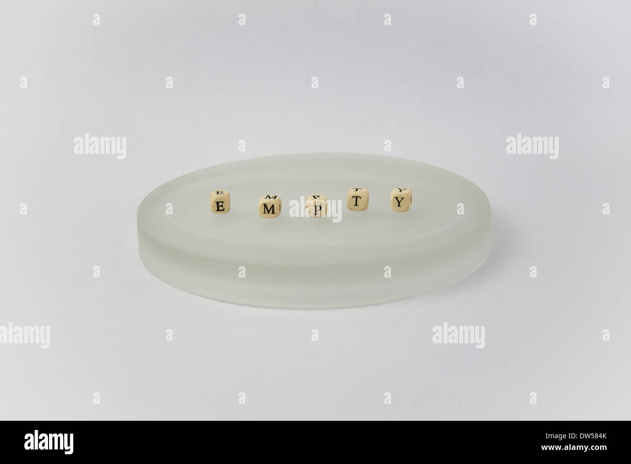 the word empty to show concept of emptiness, on a frosted white dish on ...
