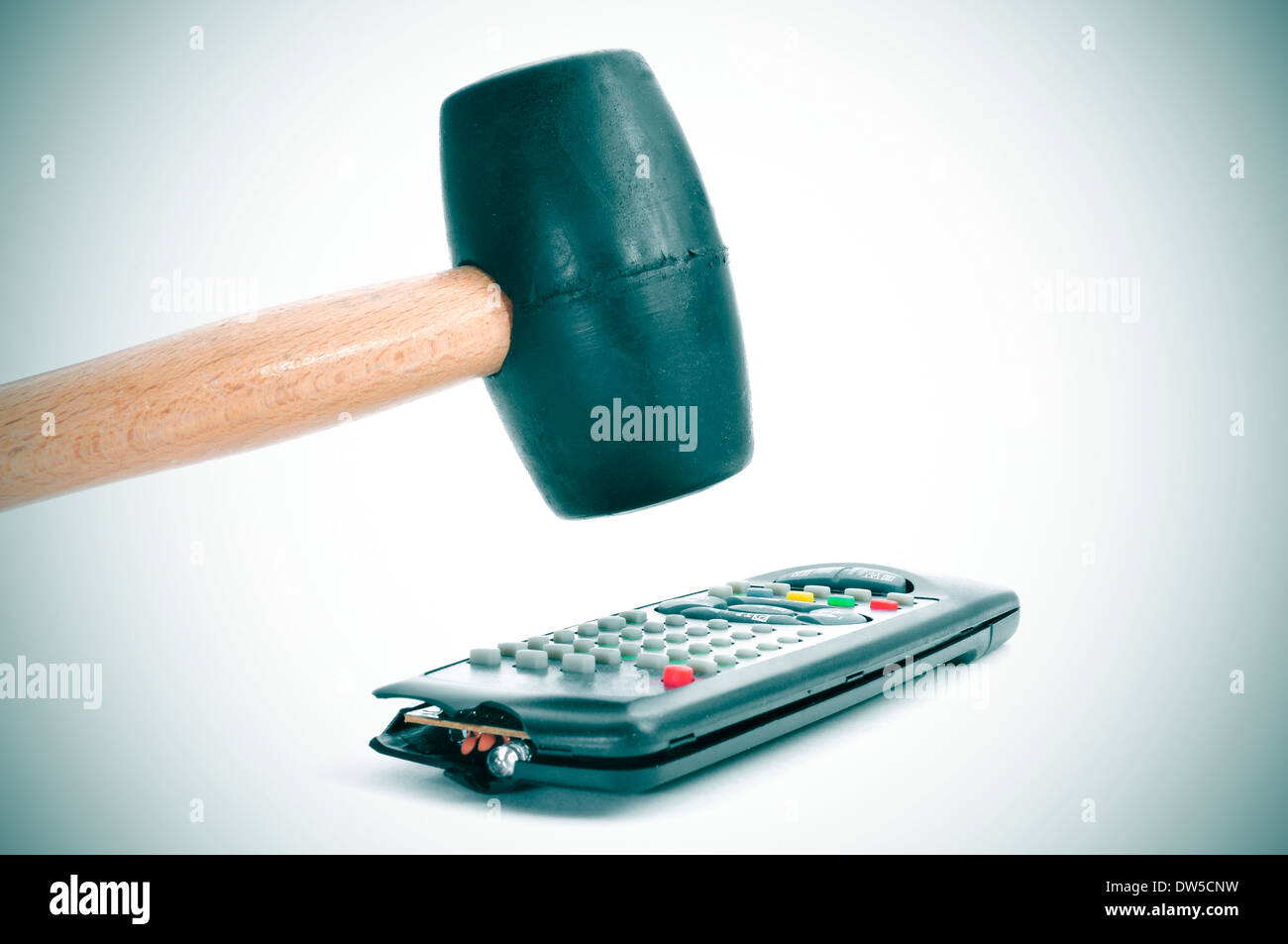 someone broking a remote control with a hammer Stock Photo - Alamy