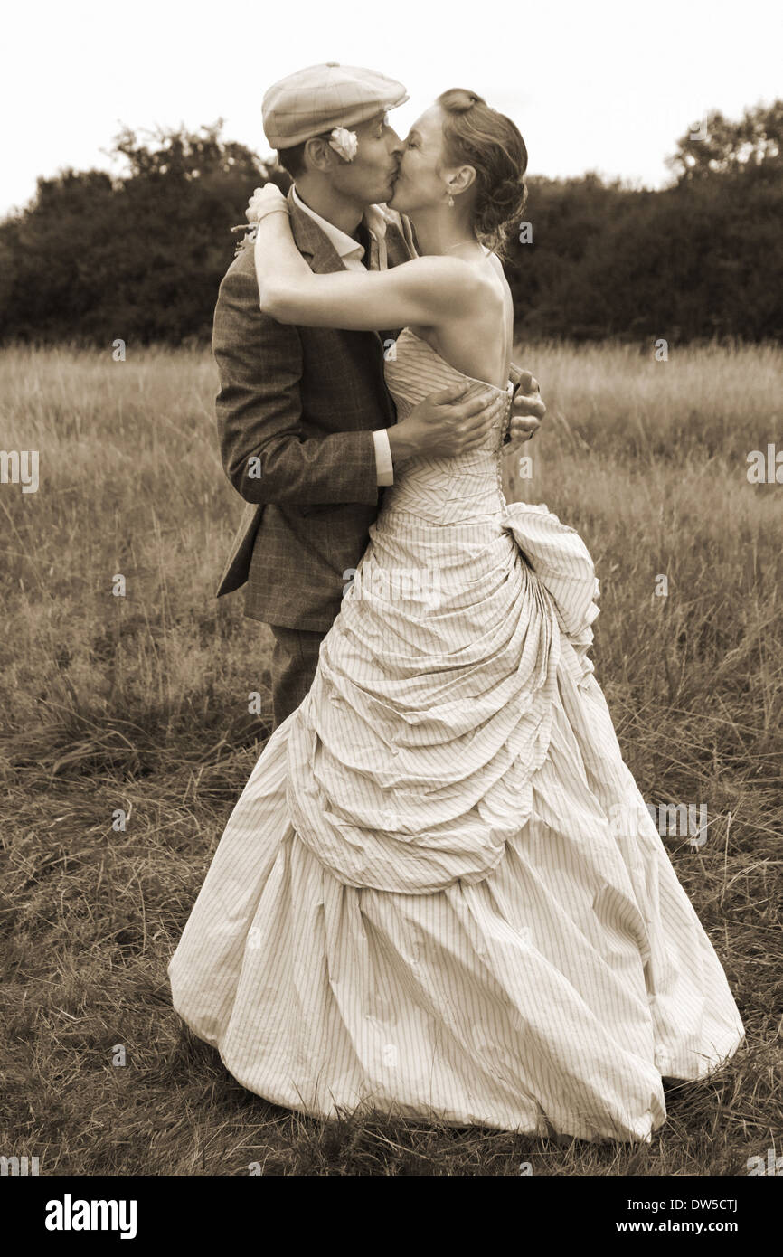 Unconventional married couple kissing in the English coungtryside Stock ...