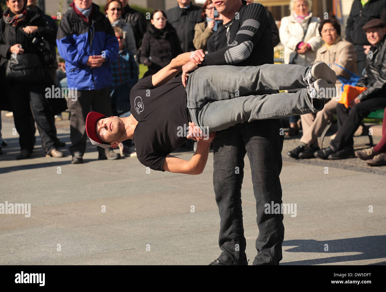 Street acrobats perform for tourists at the Brandenburg Gate in Berlin ...