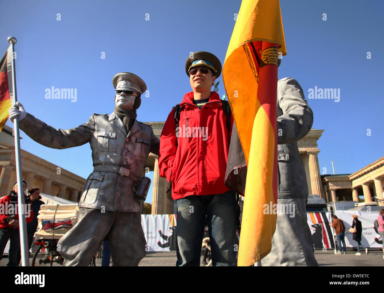 An Asian tourist (C) poses for a photo at the Brandenburg Gate in ...