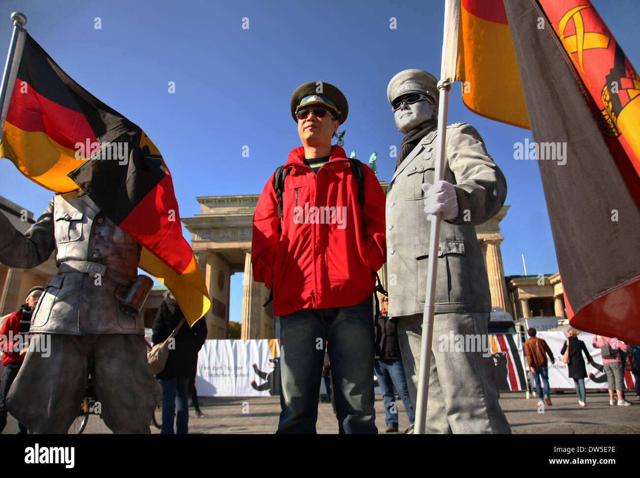 An Asian tourist (C) poses for a photo at the Brandenburg Gate in ...