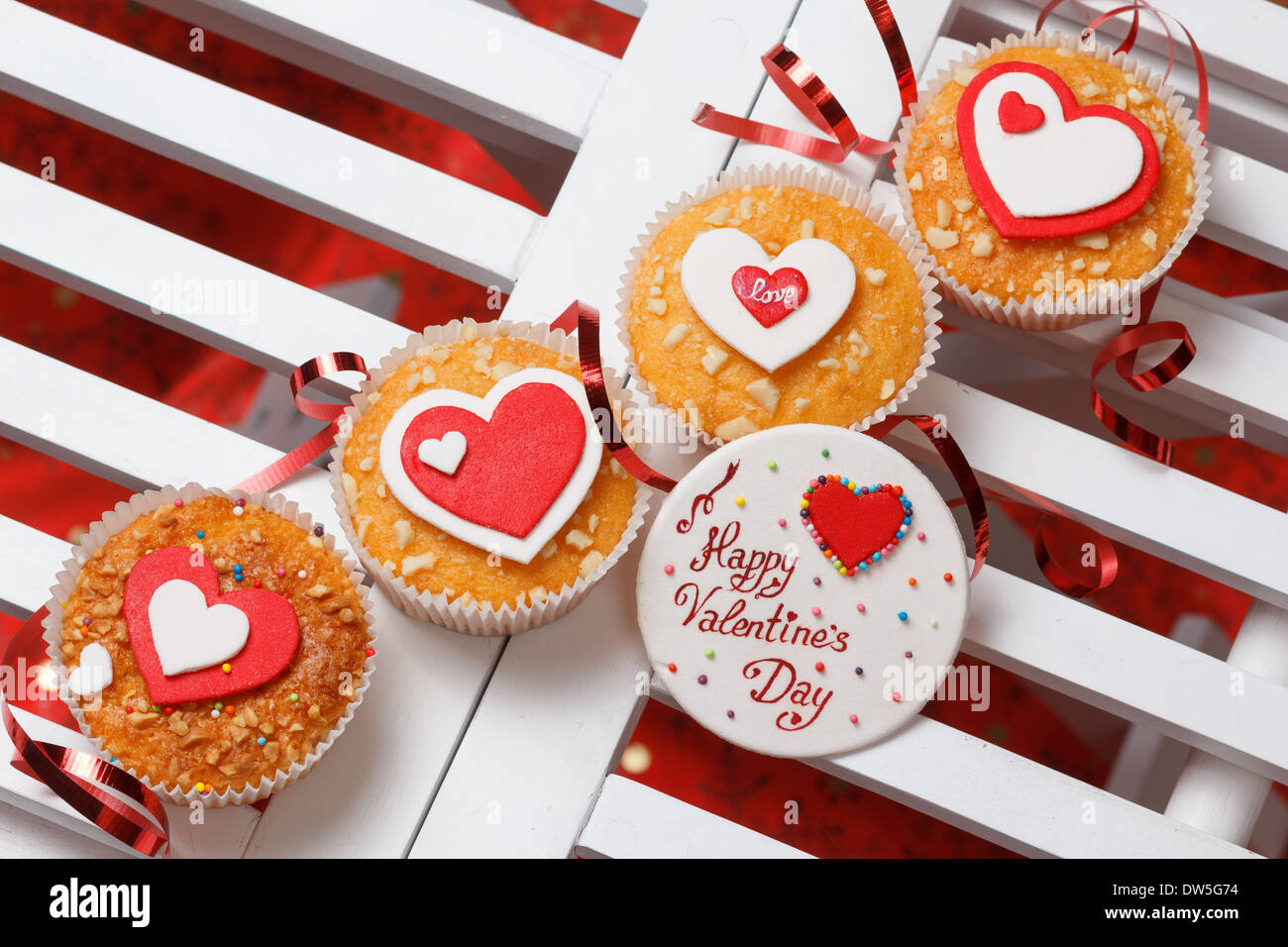 valentine's day muffins with red and white hearts on a white wooden ...