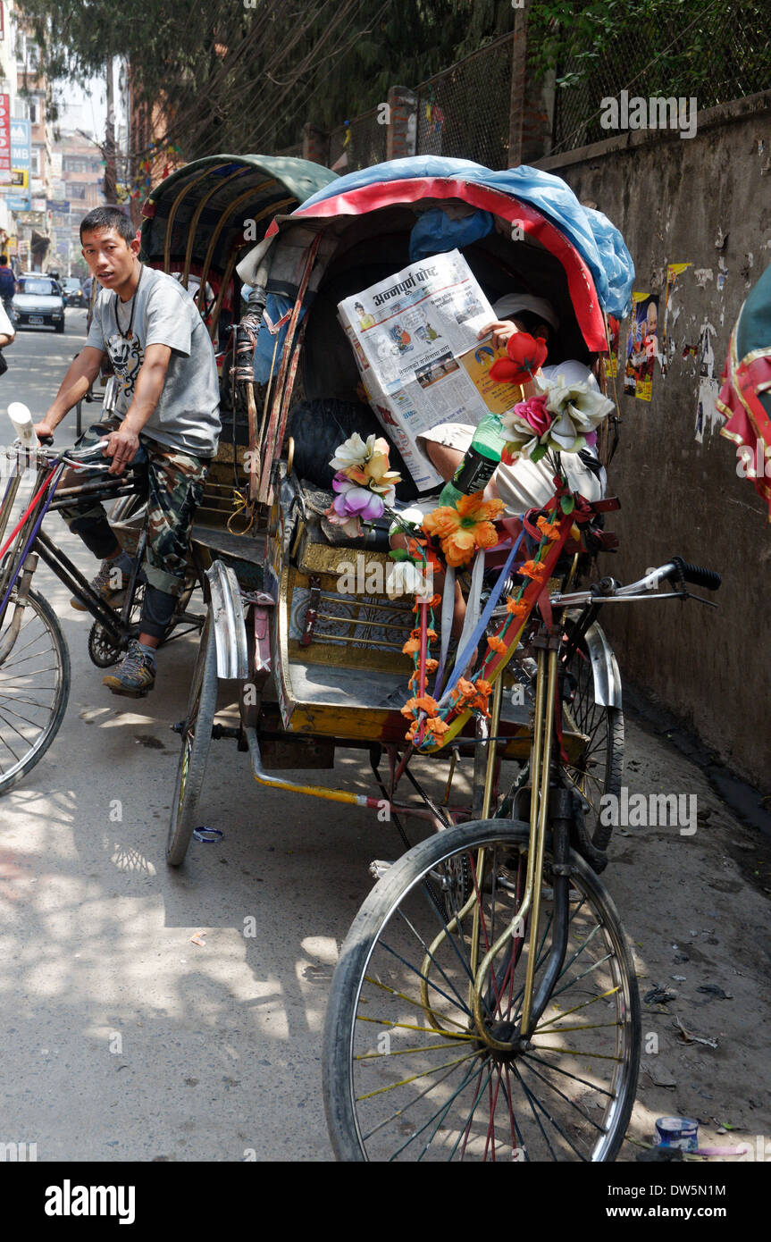 A rickshaw driver reading a newspaper in Kathmandu Nepal Stock Photo ...