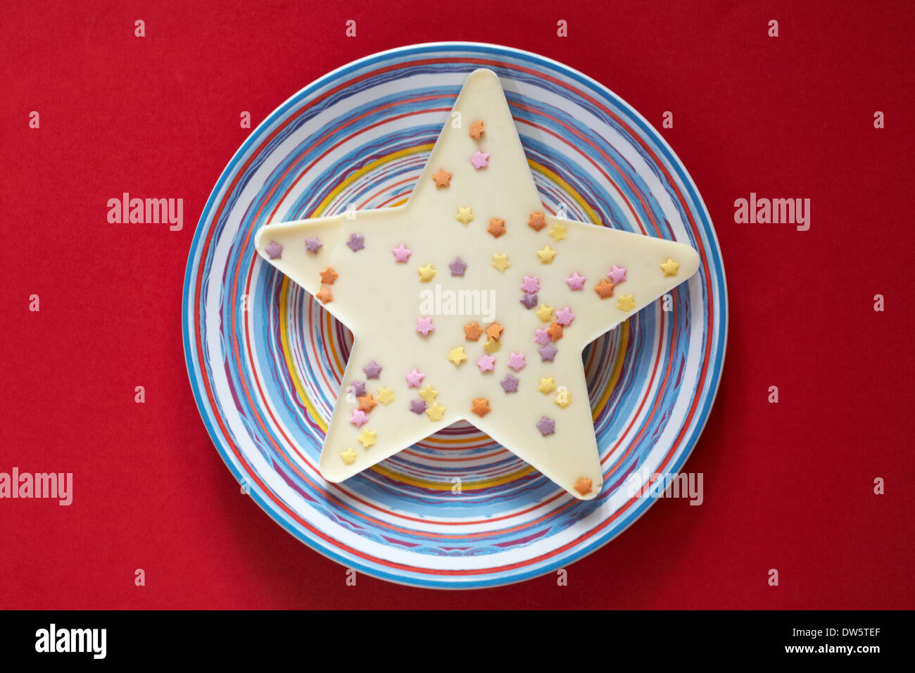 white chocolate star hand decorated with coloured sugar stars set on ...