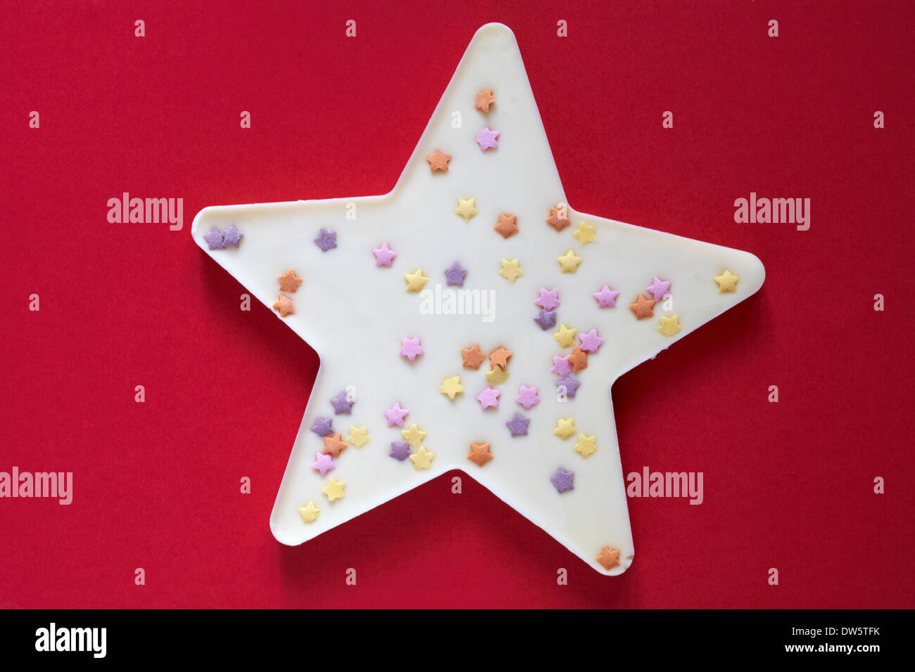 white chocolate star hand decorated with coloured sugar stars set on ...