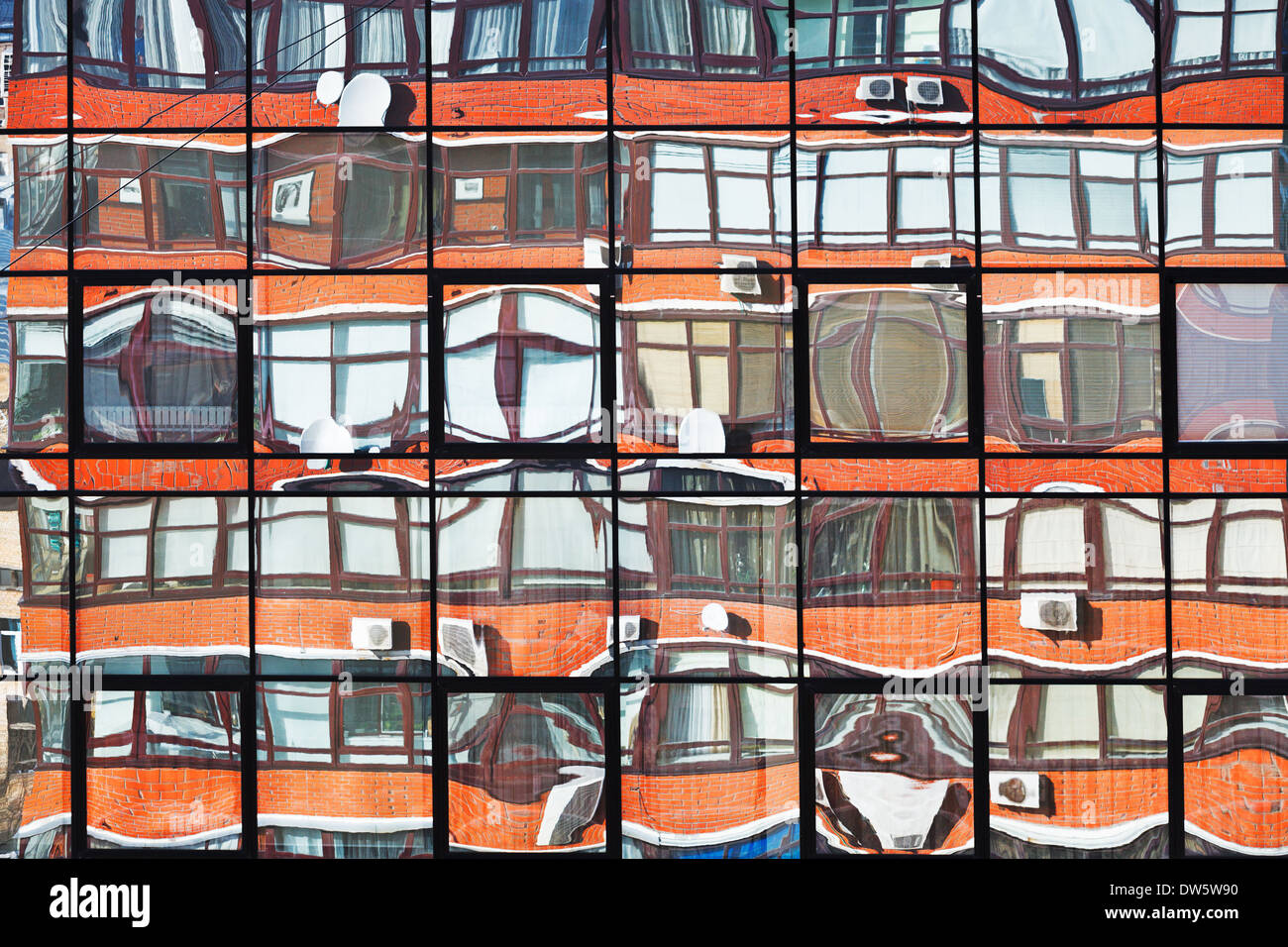 reflection of apartment house in mirror windows of office building ...